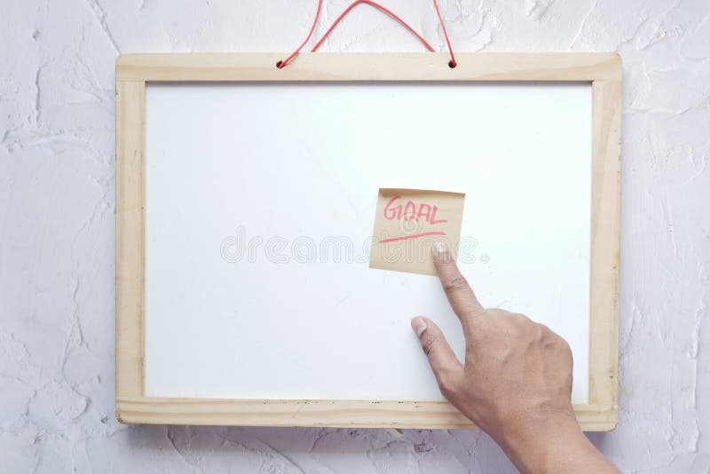 Putting a Sticky Note with Goal Word on a White Board Stock Photo ...