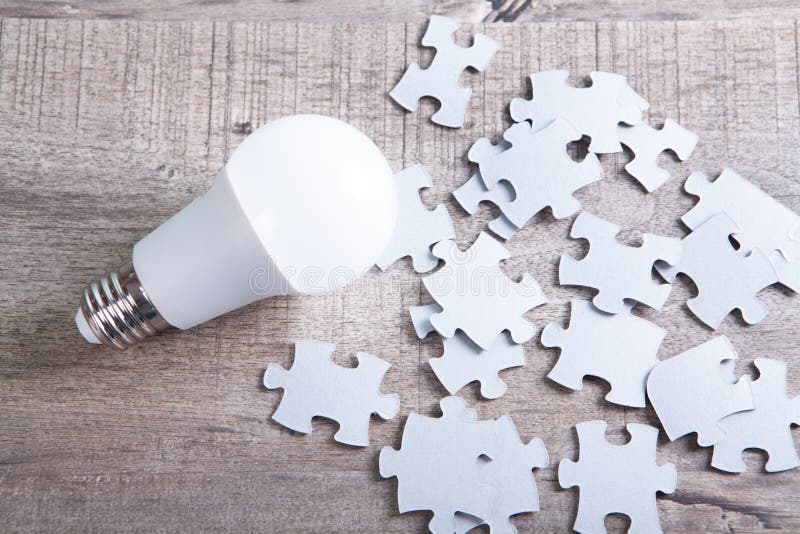 Puzzle Pieces and a Light Bulb on the Table Stock Image - Image of ...