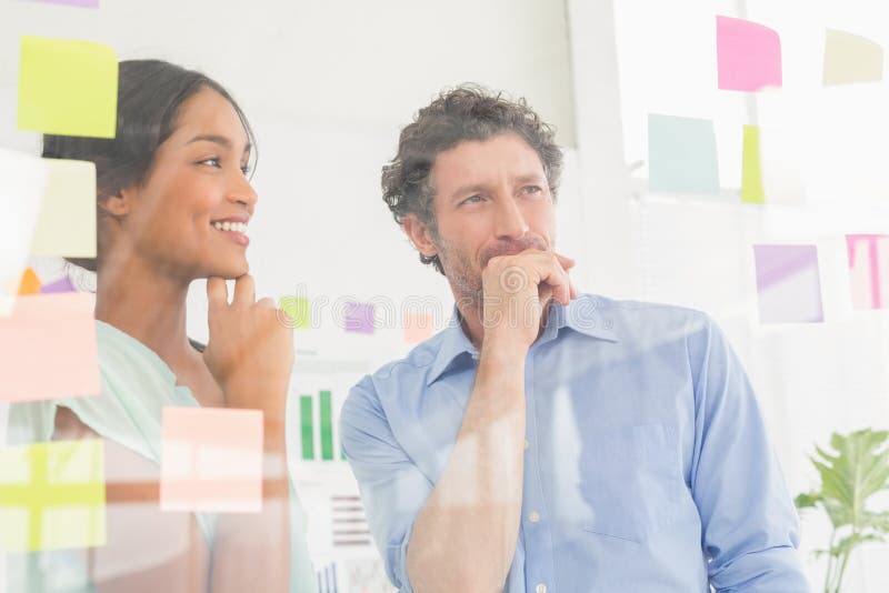 Puzzled Business Team Looking Post Its on the Wall Stock Image - Image ...
