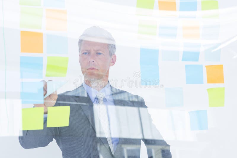 Puzzled Businessman Looking Post Its on the Wall Stock Photo - Image of ...