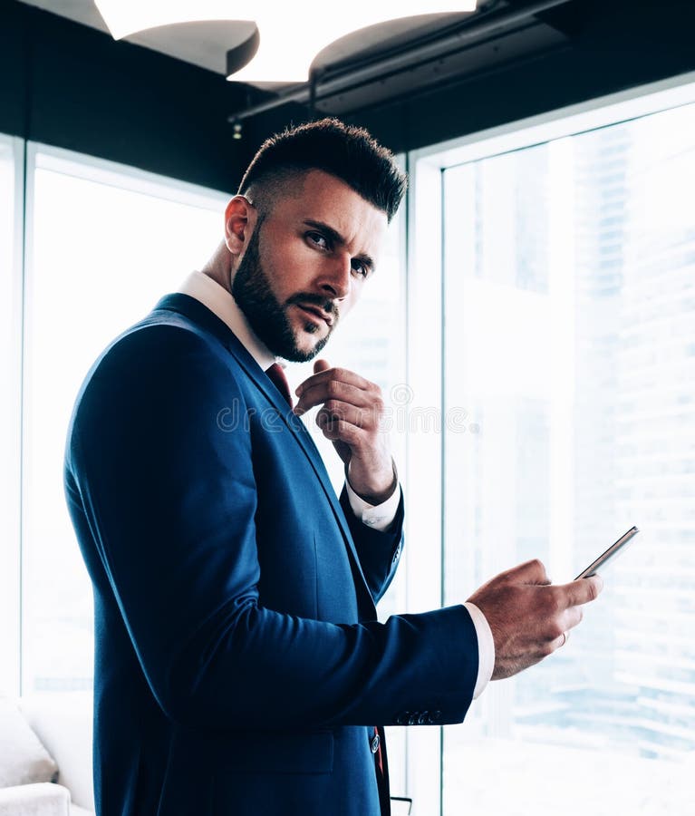 Puzzled Businessman in Suit Searching for Solution with Smartphone at ...