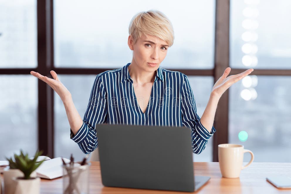 Puzzled Lady Shrugging Shoulders Gesturing with Hands Sitting in Office ...