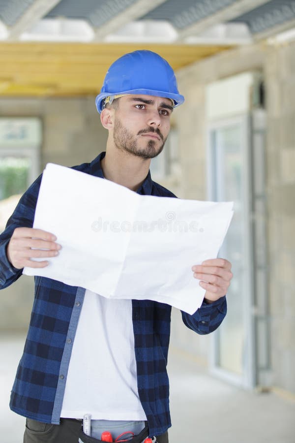 Puzzled Young Builder Handyman Examining Room and Planning Renovation ...