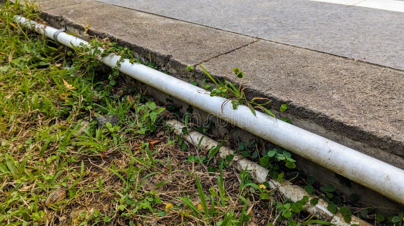 PVC Pipe Located on the Ground Near a Concrete Sidewalk, with a Small ...