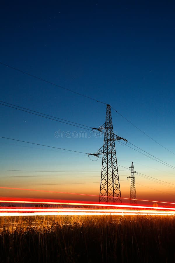 Pylons And Electricity Power Lines At Night With Traffic Lights. Stock ...
