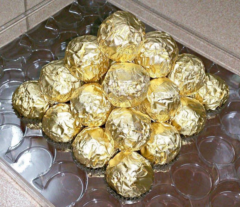 A Pyramid of Golden Foil Wrappers Stock Photo - Image of square ...