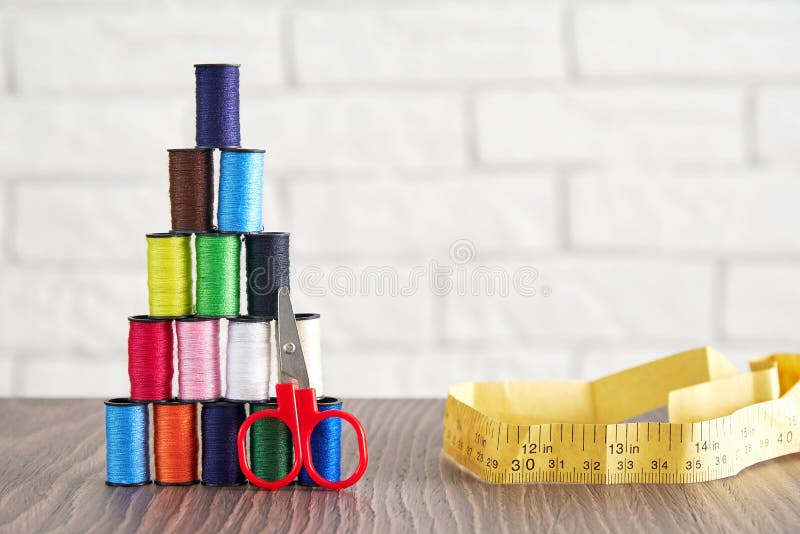 Pyramid of Spools of Multi-colored Sewing Threads, Scissors, Measuring ...