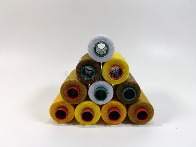 Pyramid Stack of Yellow, White, and Brown Sewing Thread Spools on White Background Stock Image ...