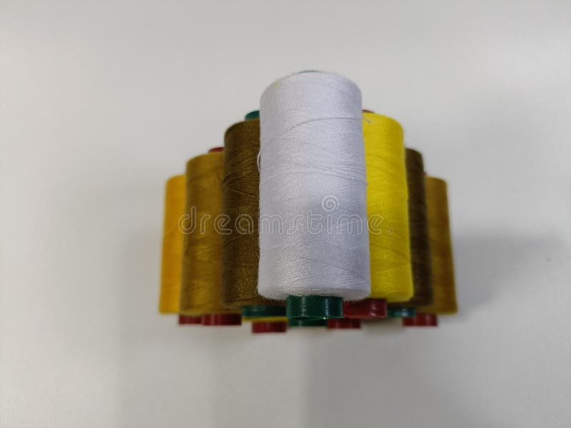 Pyramid Stack of Yellow, White, and Brown Sewing Thread Spools on White Background Stock Image ...
