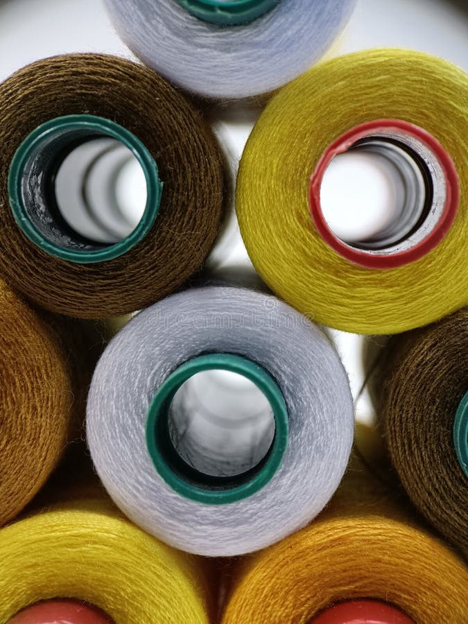 Pyramid Stack of Yellow, White, and Brown Sewing Thread Spools on White Background Stock Image ...
