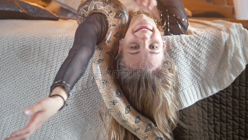 Python Crawling on the Body of Young Smiling Female Dancer on the Bed ...
