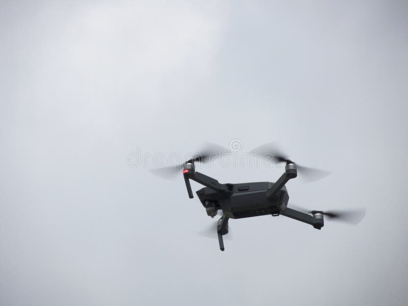 Quadcopter Drone Flying Overhead in Cloudy Sky Stock Image - Image of ...