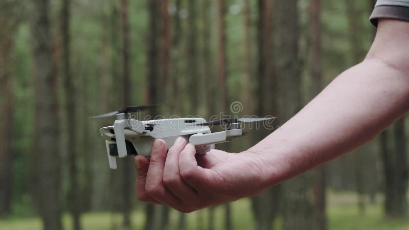 A Quadcopter Operator with a Remote Control Holds the Drone in Front of ...