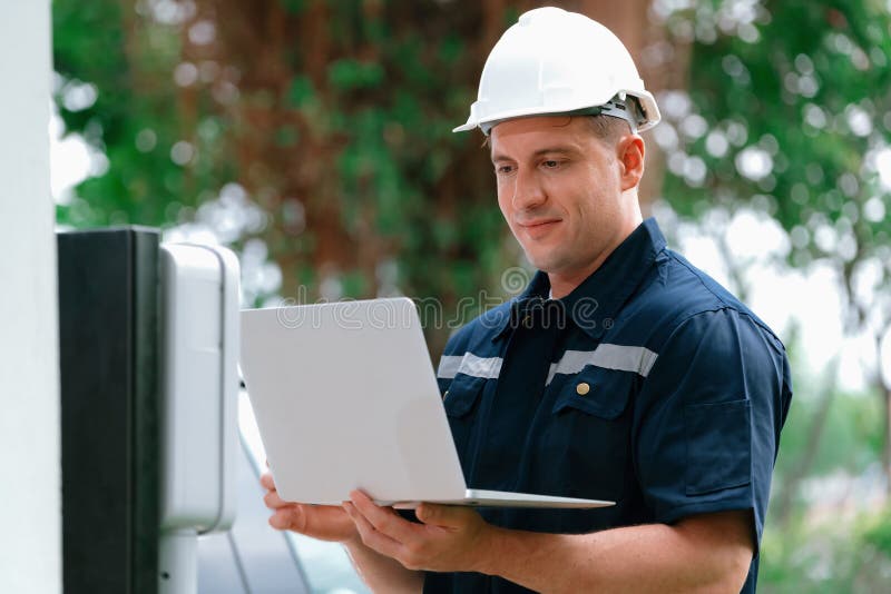 Qualified Technician Working with Laptop for Home EV Station ...