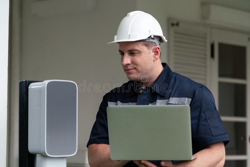 Qualified Technician Working with Laptop for Home EV Station ...