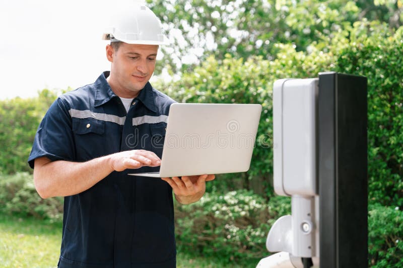 Qualified Technician Working with Laptop for Home EV Station ...