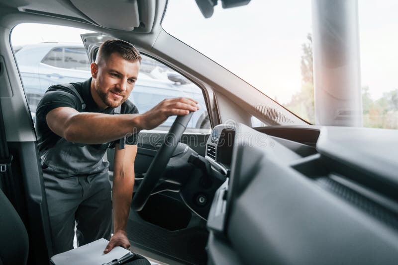 Quality Control. Man in Uniform is Working in the Autosalon at Daytime ...