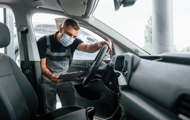 Quality Control. Man in Uniform is Working in the Autosalon at Daytime ...