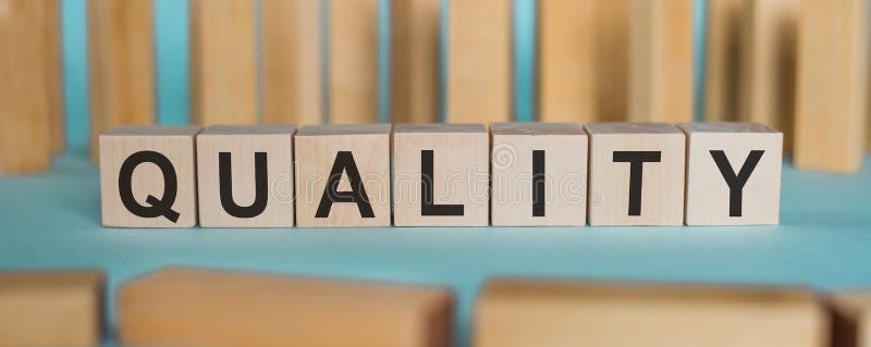QUALITY Word Written from Wooden Blocks on Blue Background Stock Photo ...