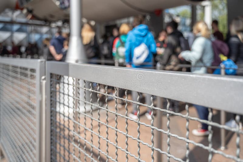 Queue in a Park with a Security Fence Stock Photo - Image of blur ...