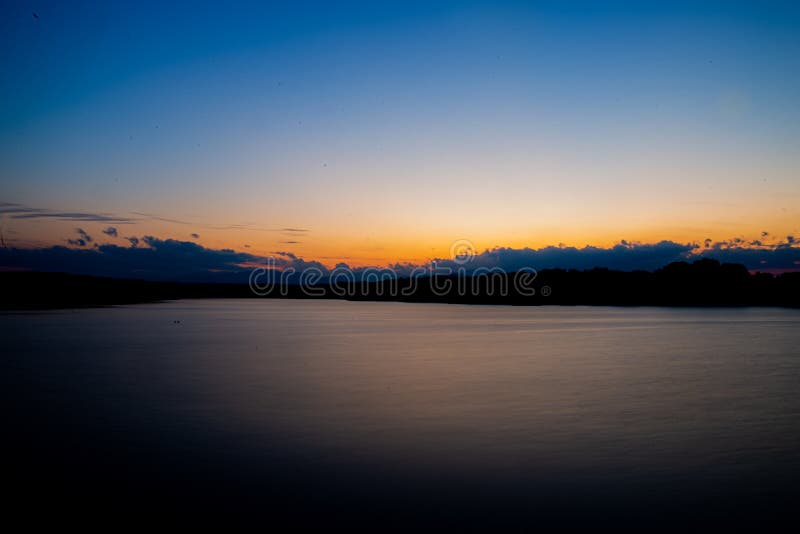 Quiet lake at sunset time stock image. Image of evening - 220567615