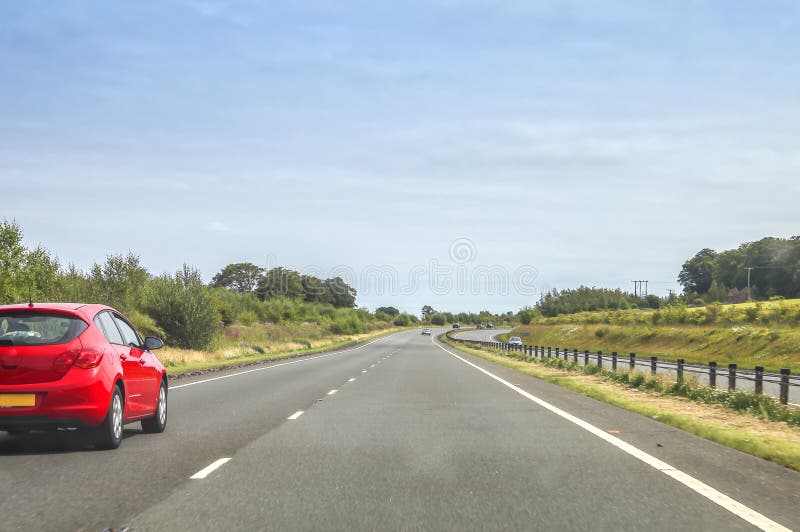 Quiet Road with Red Car Driving on Left Side Stock Image - Image of ...