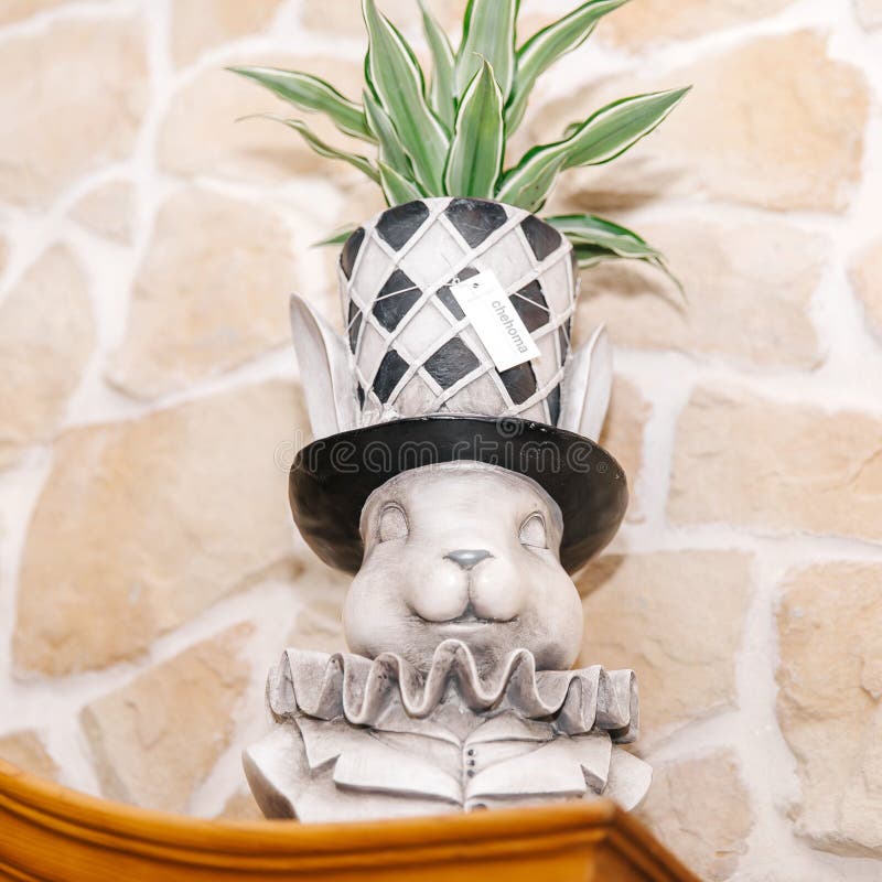 Quirky Rabbit Sculpture with Top Hat Planter Against Stone Wall Decor ...