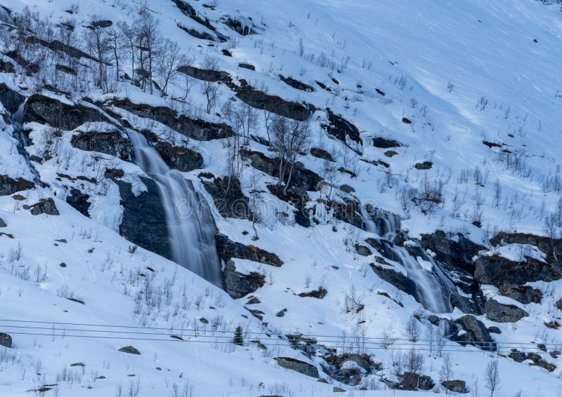 Røldal Waterfall at the End of Winter, Mountain Slopes Covered with ...
