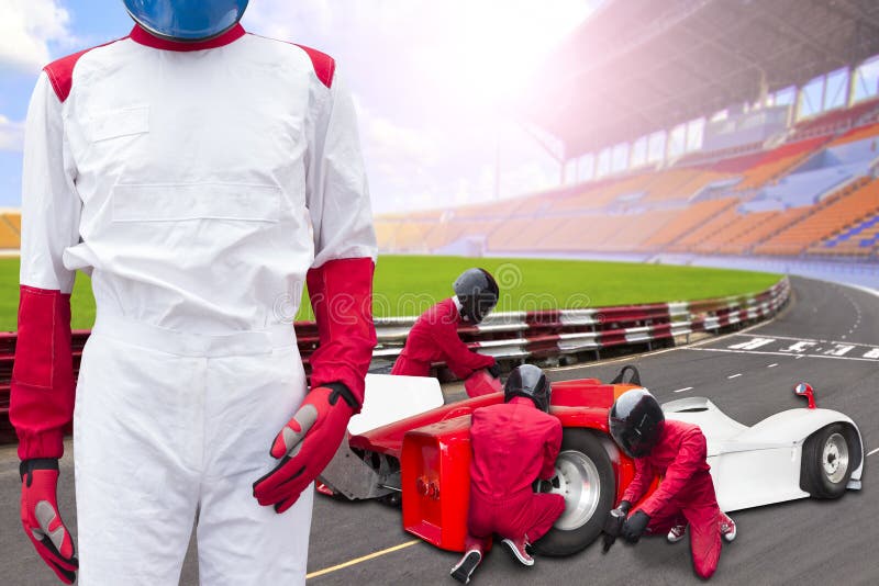 Race Car Driver Posing in Front of the Pit Stop with Team Maintaining ...
