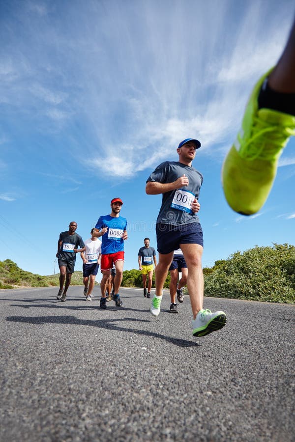 Race for it. Low Angle Shot of a Group of Young Men Running a Marathon ...