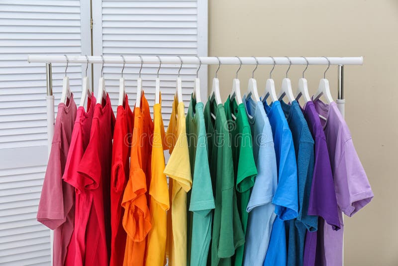 Rack with Bright Clothes in Room Stock Photo - Image of light, blue ...