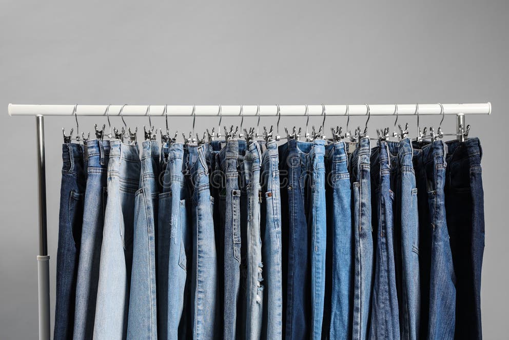 Rack with Different Jeans on Grey Background Stock Photo - Image of ...