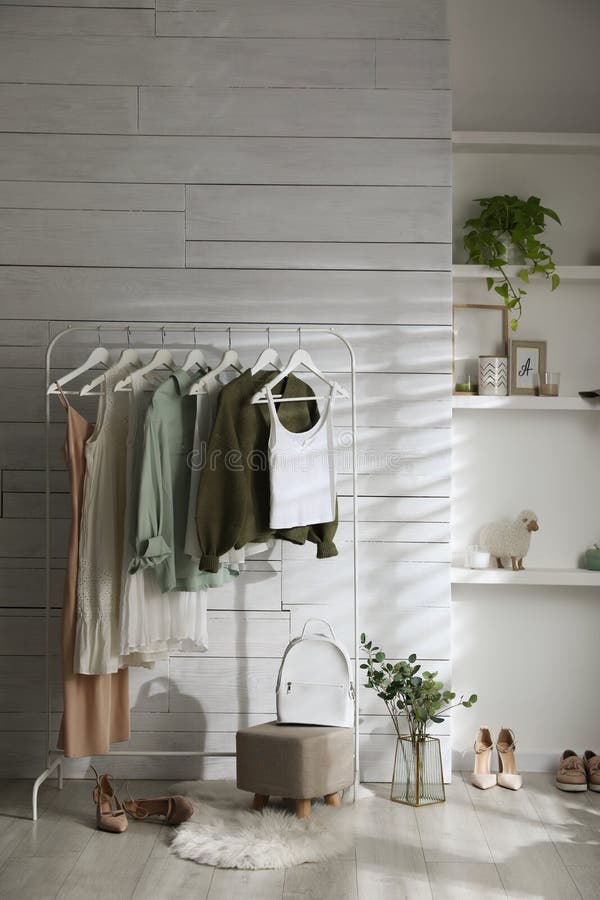 Rack with Different Stylish Clothes, Shoes and Decorative Elements in ...