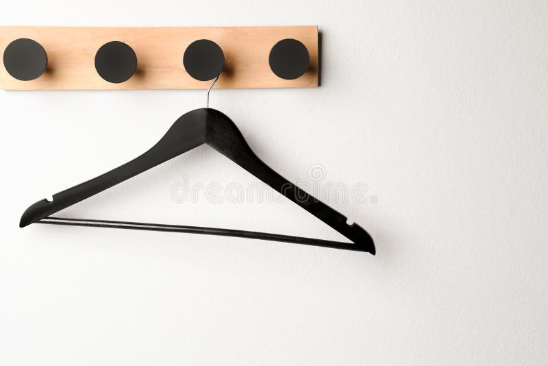 Rack with Empty Black Clothes Hanger on White Wall Stock Photo - Image ...