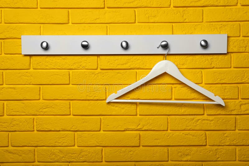 Rack with Empty Clothes Hanger on Yellow Brick Wall Stock Image - Image ...