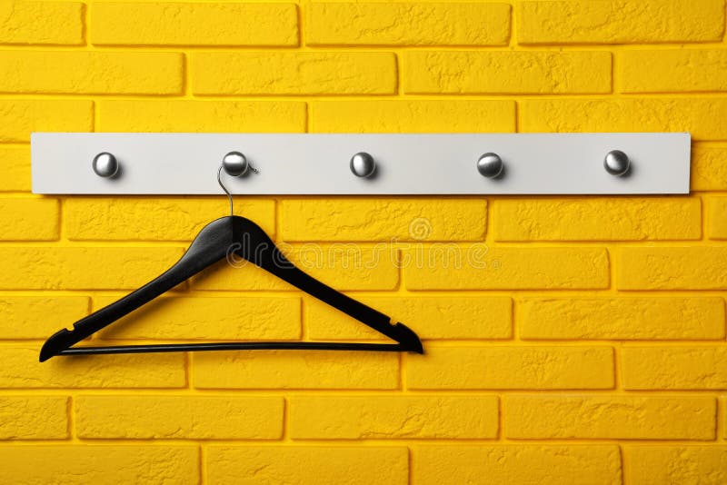 Rack with Empty Clothes Hanger on Yellow Brick Wall Stock Image - Image ...