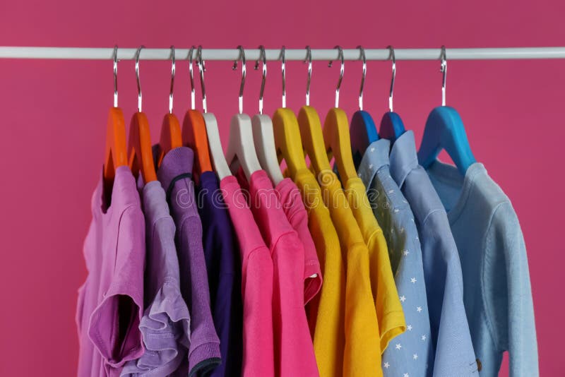 Rack with Stylish Children Clothes on Pink Background Stock Photo ...