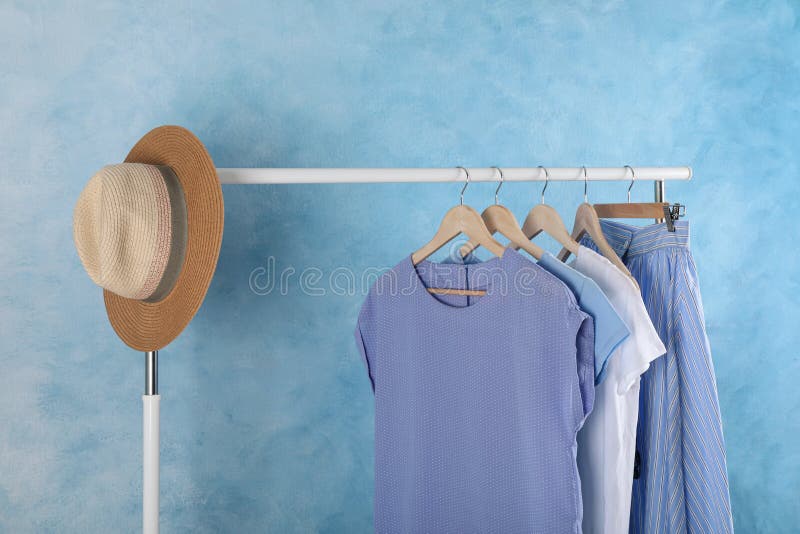 Rack with Stylish Clothes Near Light Blue Wall Indoors Stock Photo ...