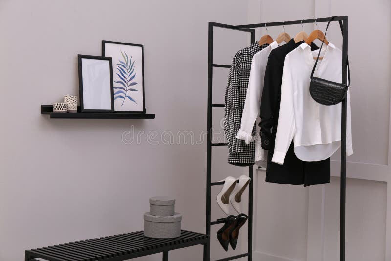 Rack with Stylish Women`s Clothes and Bench in Dressing Room Stock ...