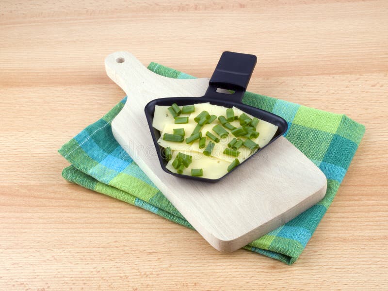 Raclette Pan with Cheese and Spring Onion Stock Photo - Image of board ...