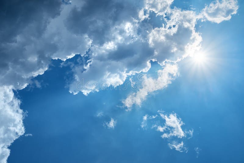 Radiant Sun Behind Dark Clouds in a Blue Sky Stock Photo - Image of ...