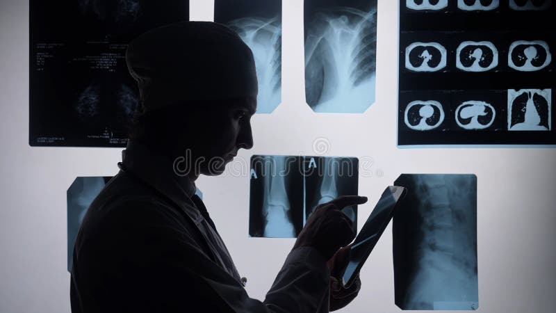 Radiologist Examining X Ray Images on a Digital Tablet Stock Photo ...