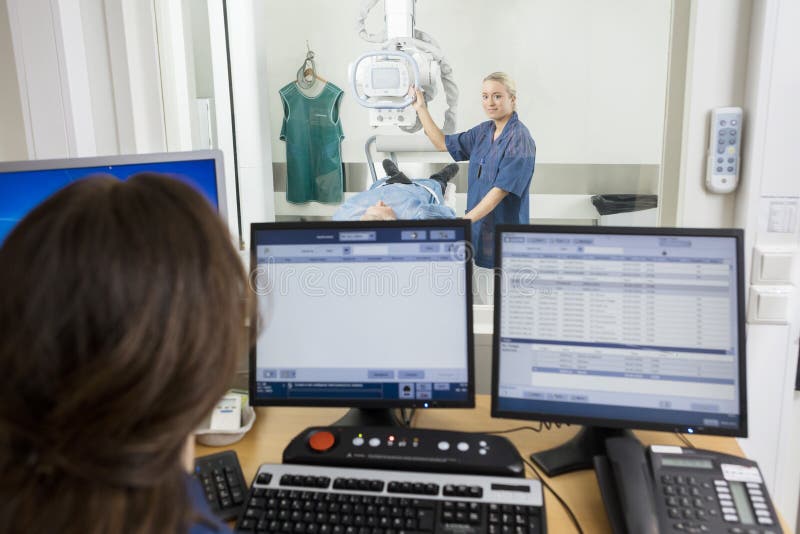 Radiologist Taking Patients Xray while Coworker Using Computers Stock ...
