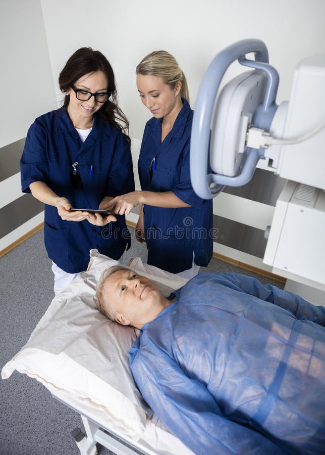 Radiologists Using Digital Tablet while Patient Standing at Xray Stock ...