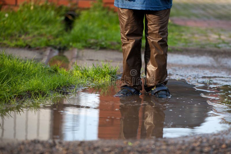 Ragazzino Che Spruzza in Una Pozza Di Fango, Immagine Stock - Immagine ...