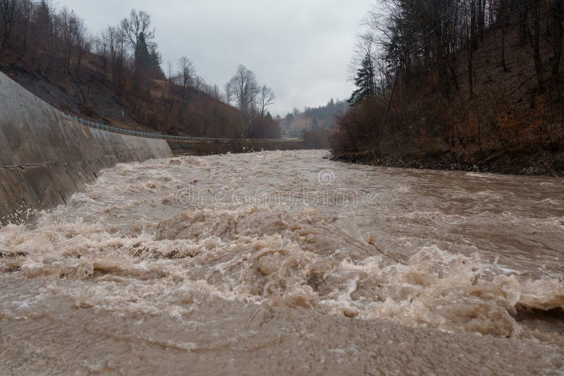 Raging Floodwaters Surge through a Rain-Swept River Valley Stock Photo ...