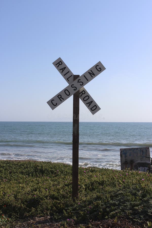 Rail Road Crossing Sign with Ocean and Blue Sky Background Stock Photo ...
