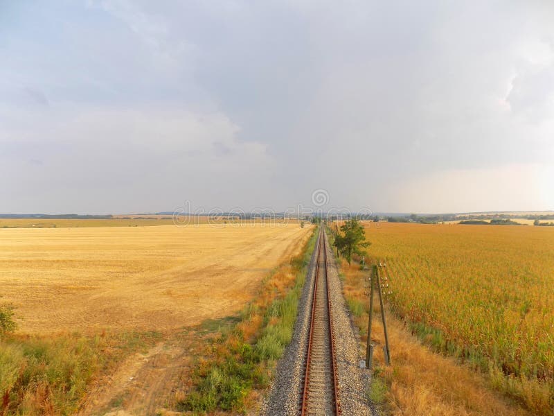 Railroad between fields stock photo. Image of clouds - 65649754