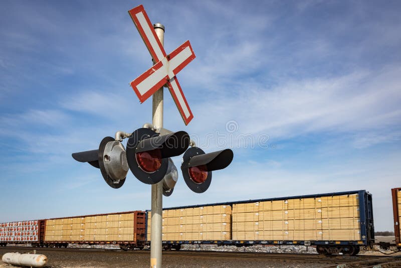 Railway Crossing Sign in Front of Freight Train Carrying Lumber Stock ...