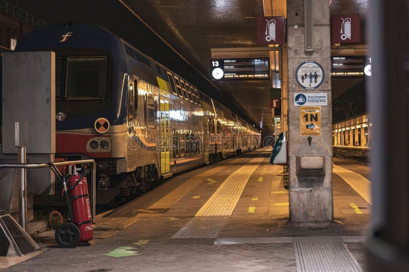 A Train Parked Next To a Platform at Night with Lights on Editorial ...